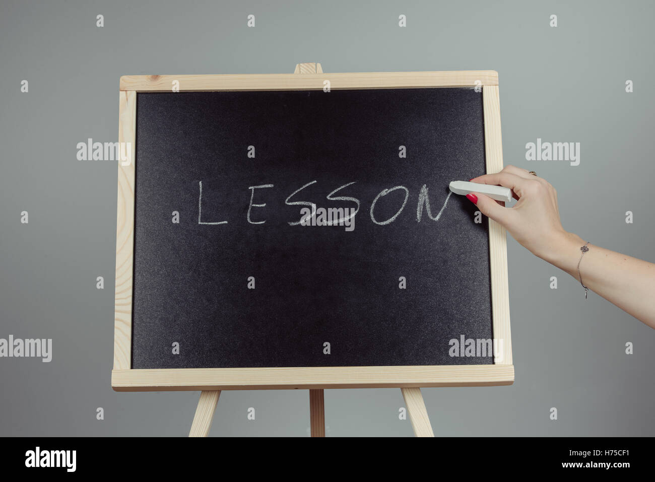 Lesson written in white chalk on a black chalkboard . gray background ...