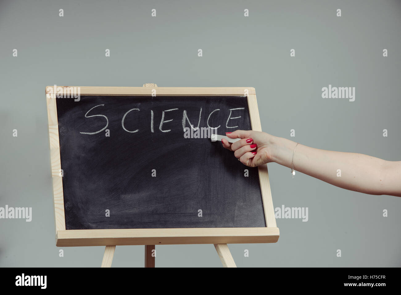 A teacher writing science, drawing chemistry elements on dark ...