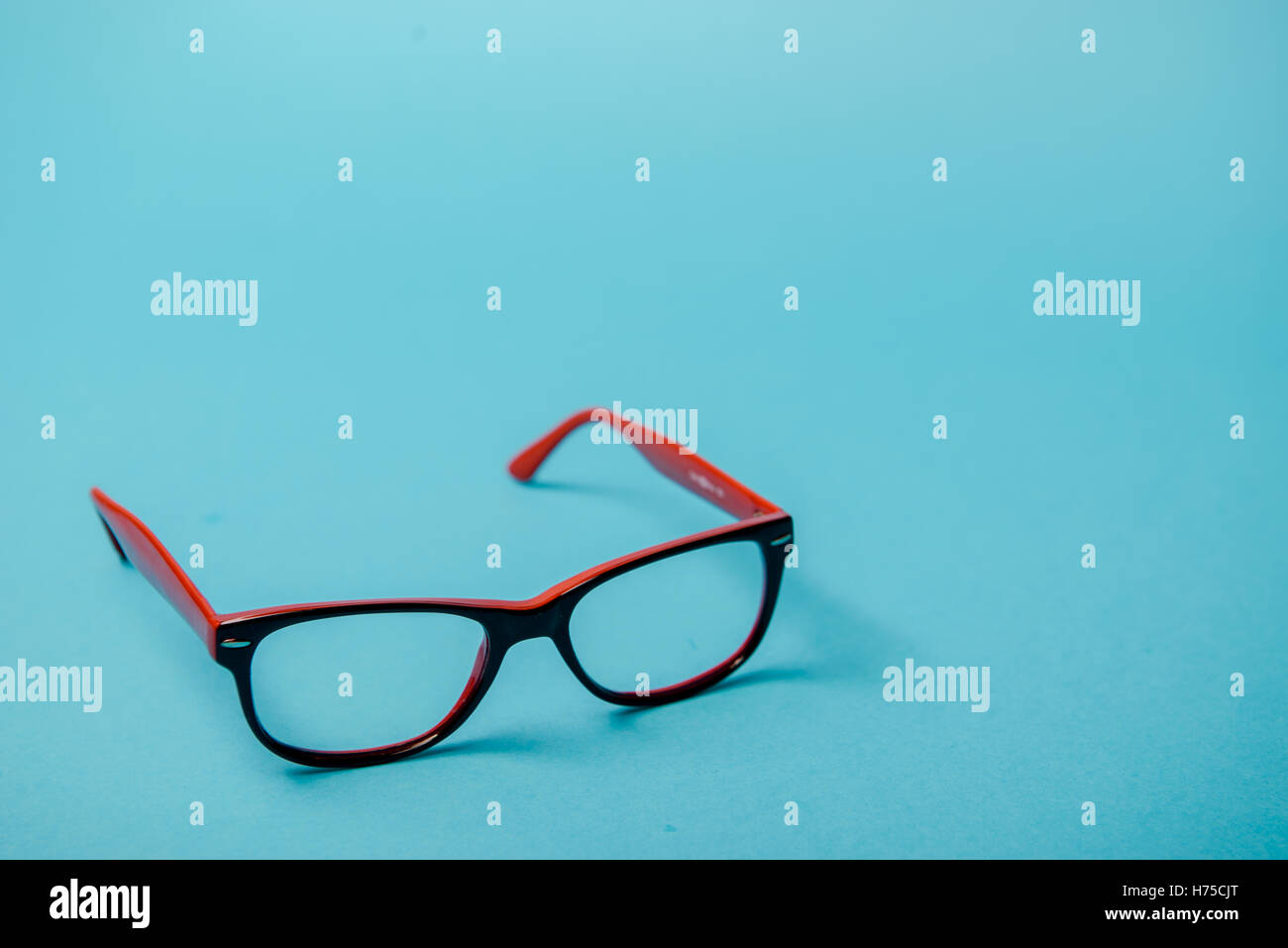 pair of red plastic-rimmed eyeglasses on a blue background Stock Photo ...