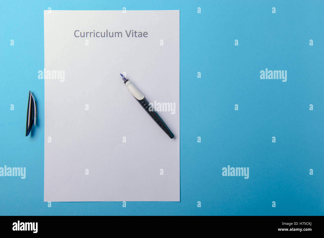 Curriculum vitae written on an blank white paper on blue background ...