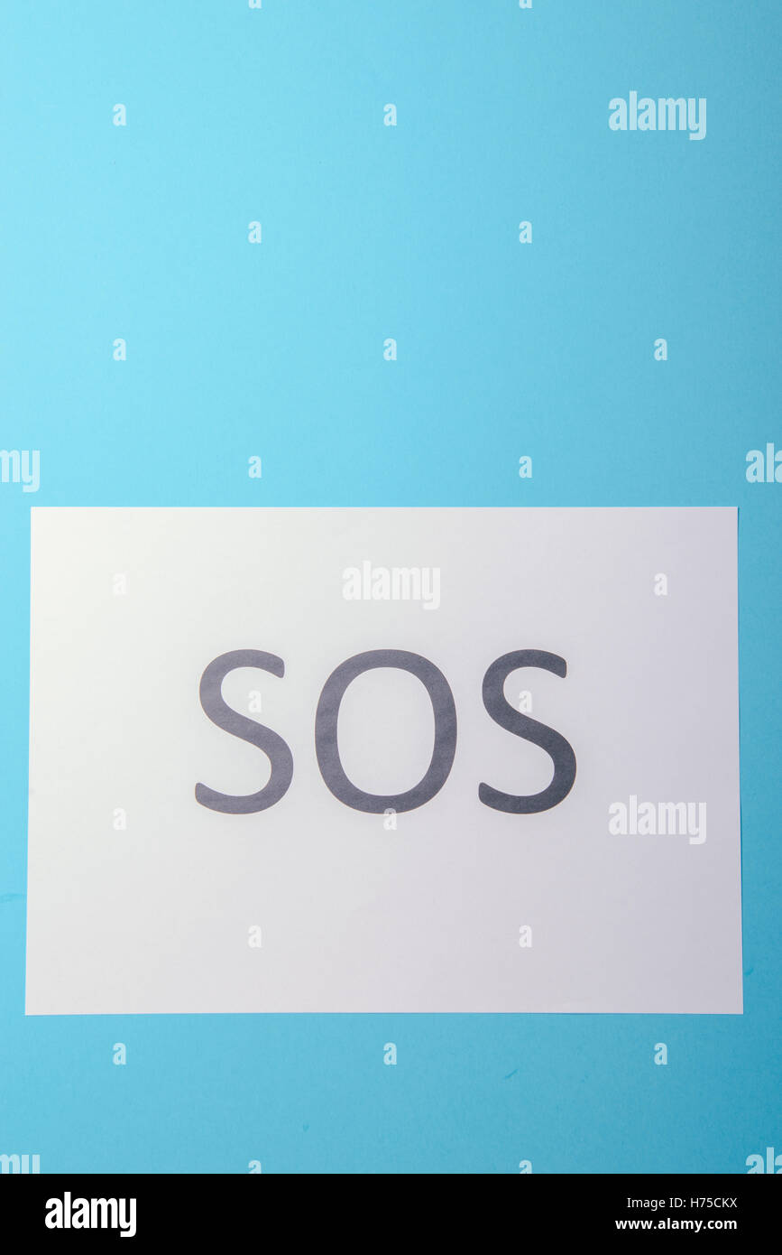 Word SOS written on white paper. Blue background Stock Photo - Alamy