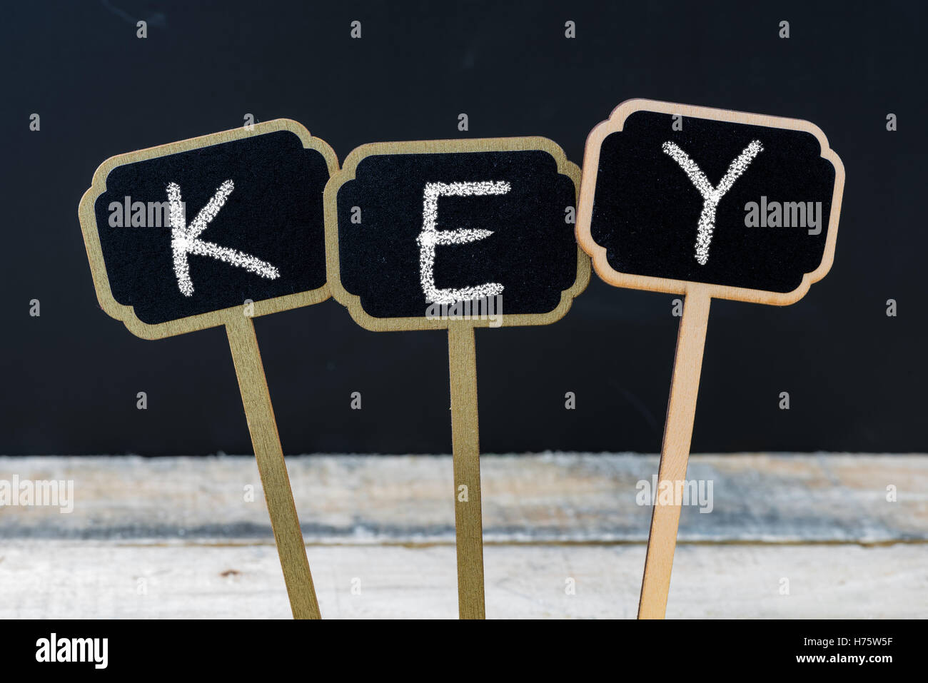 Word KEY written with chalk on wooden mini blackboard labels, defocused ...