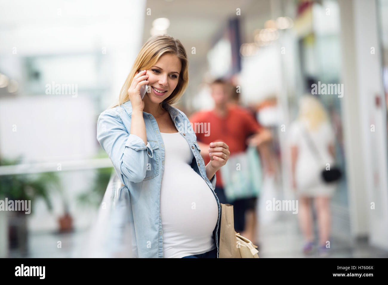 Pregnant woman in shopping center making phone call Stock Photo - Alamy