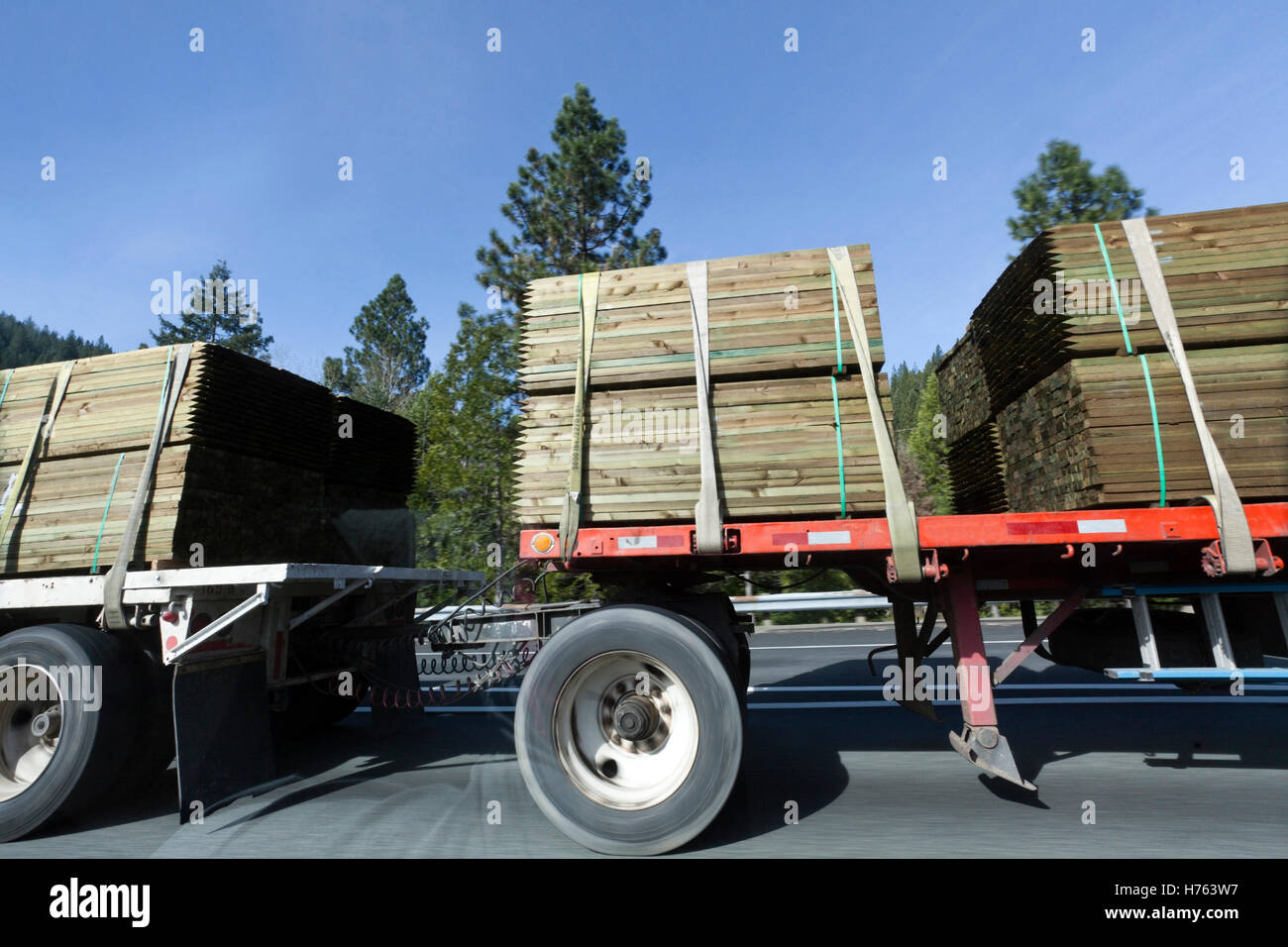Side view of flatbed hauling, lumber freight Stock Photo - Alamy