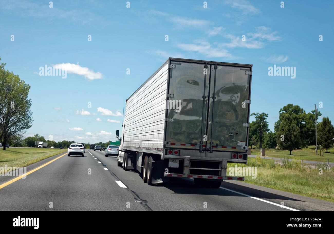 Rear view of semi truck and trailer on highway under blue sky Stock ...