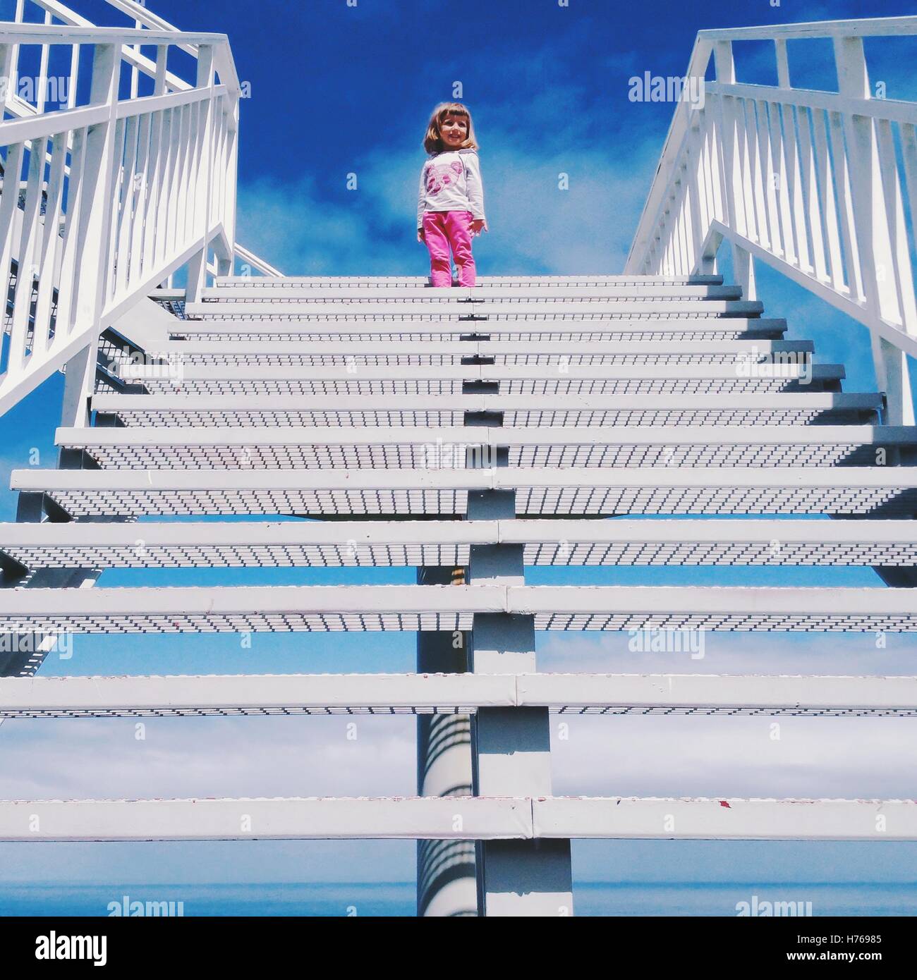 Girl standing at the top of a staircase Stock Photo - Alamy