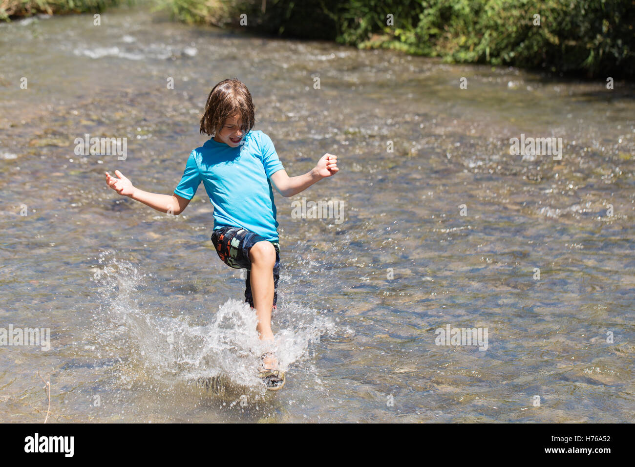 Boy splashing water in a river Stock Photo - Alamy