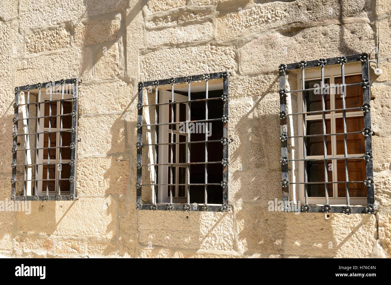 Iron latticed windows on stone wall of a building of Tui, a town in the ...