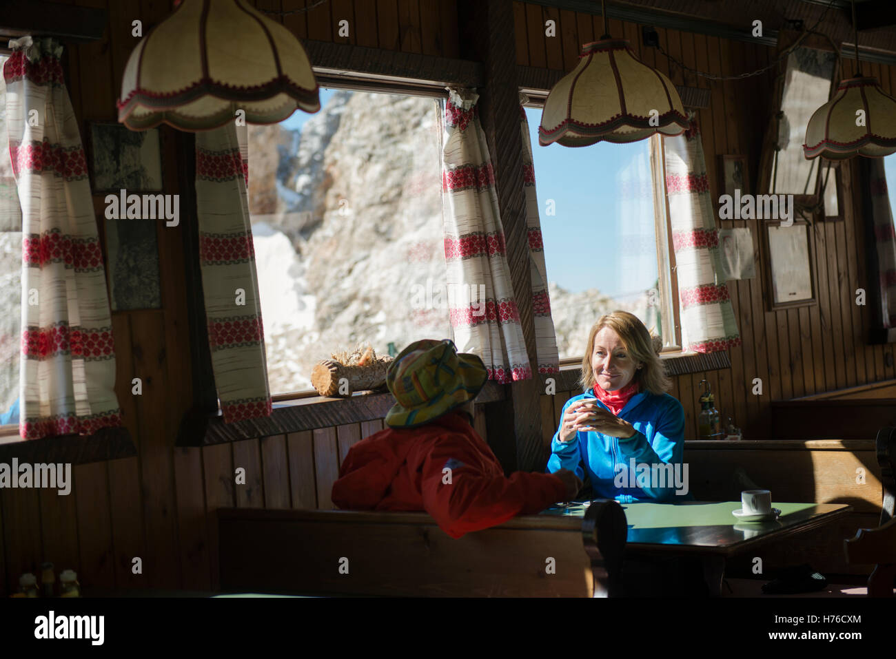 A couple having a coffee inside a Rifugio at the Dolomites, Italy Stock ...