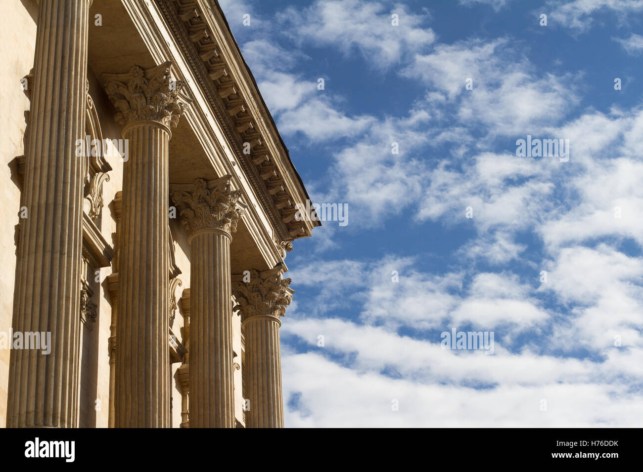 Horizontal photo of classical building columns with blue sky and clouds ...