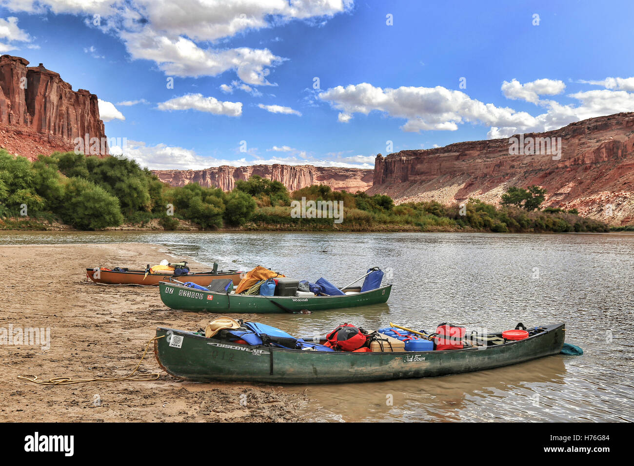 Colorfully packed canoes on the shore along the Green River in ...