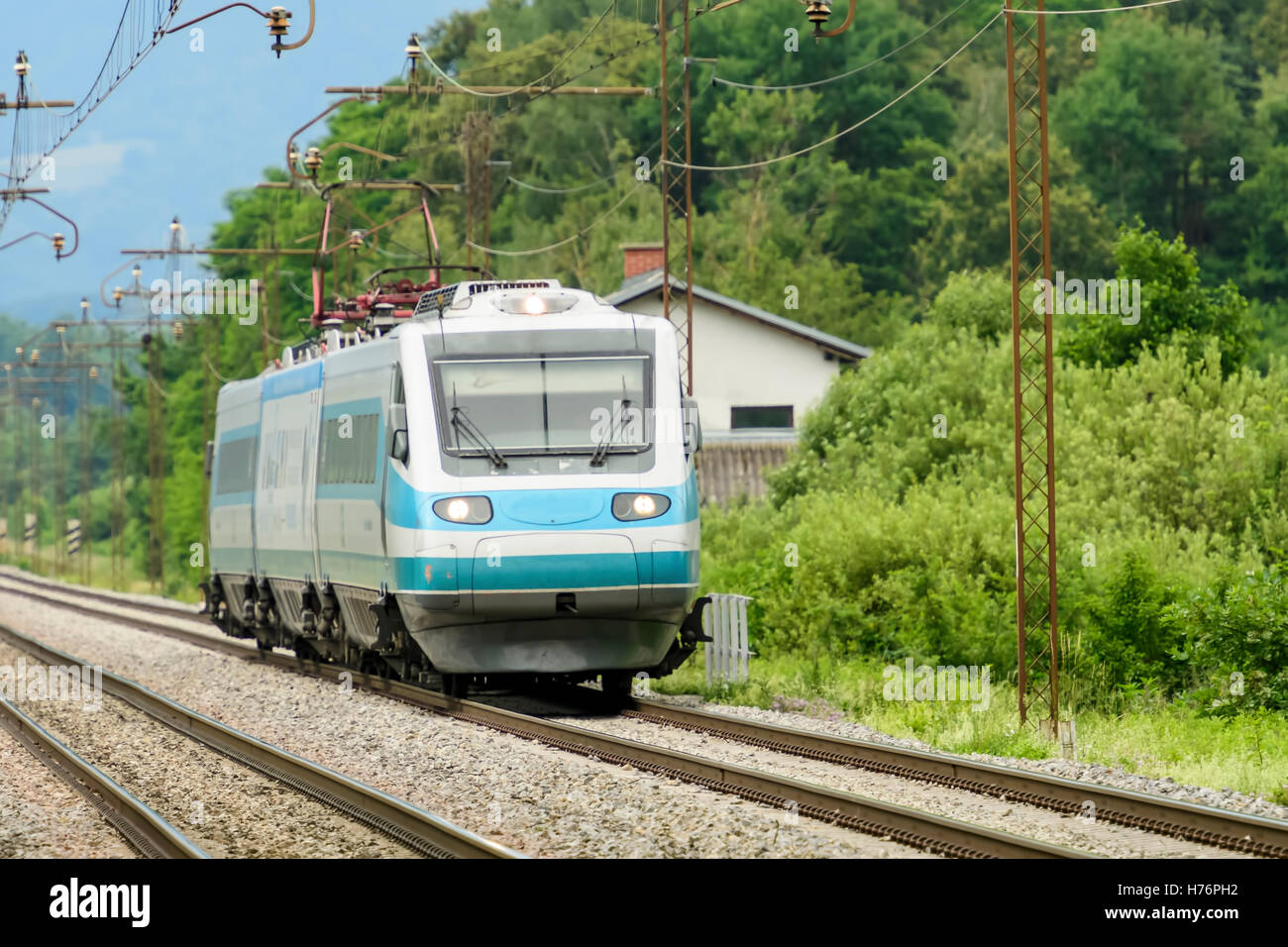 High speed passenger train approaching head on in wooden landscape ...