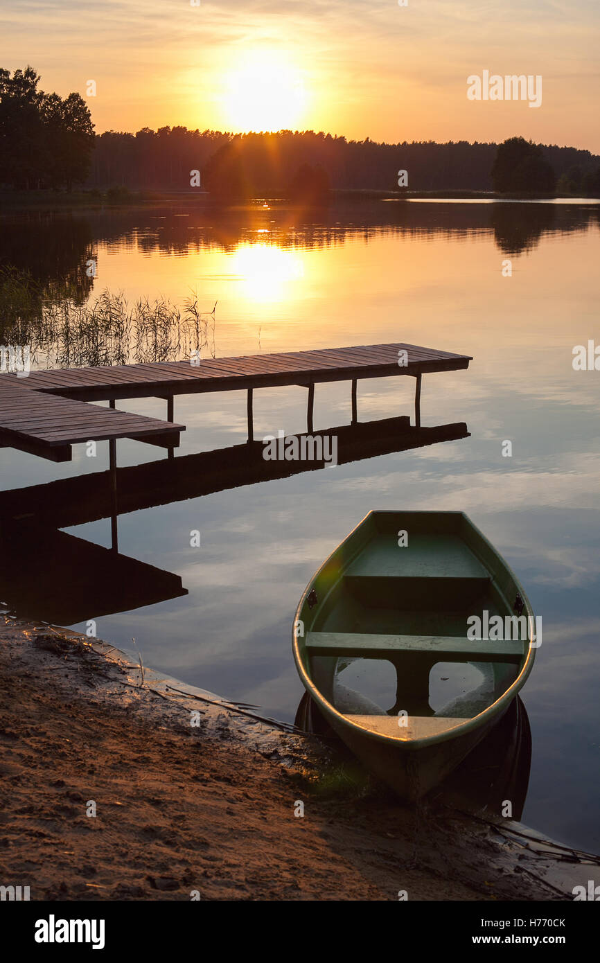 Landscape with boat and sunset on lake Stock Photo - Alamy