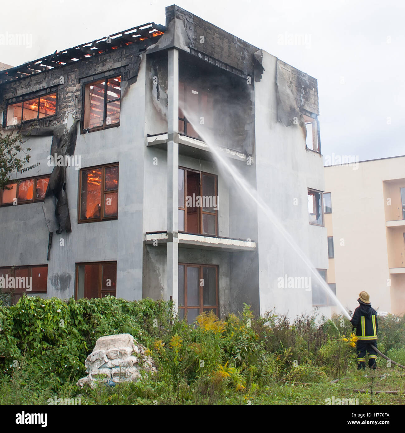 Firefighter fight a fire with a water hose Stock Photo - Alamy