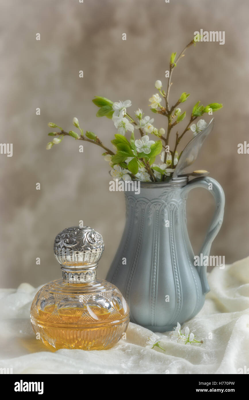 Antique perfume bottle with antique jug filled with spring blossom ...