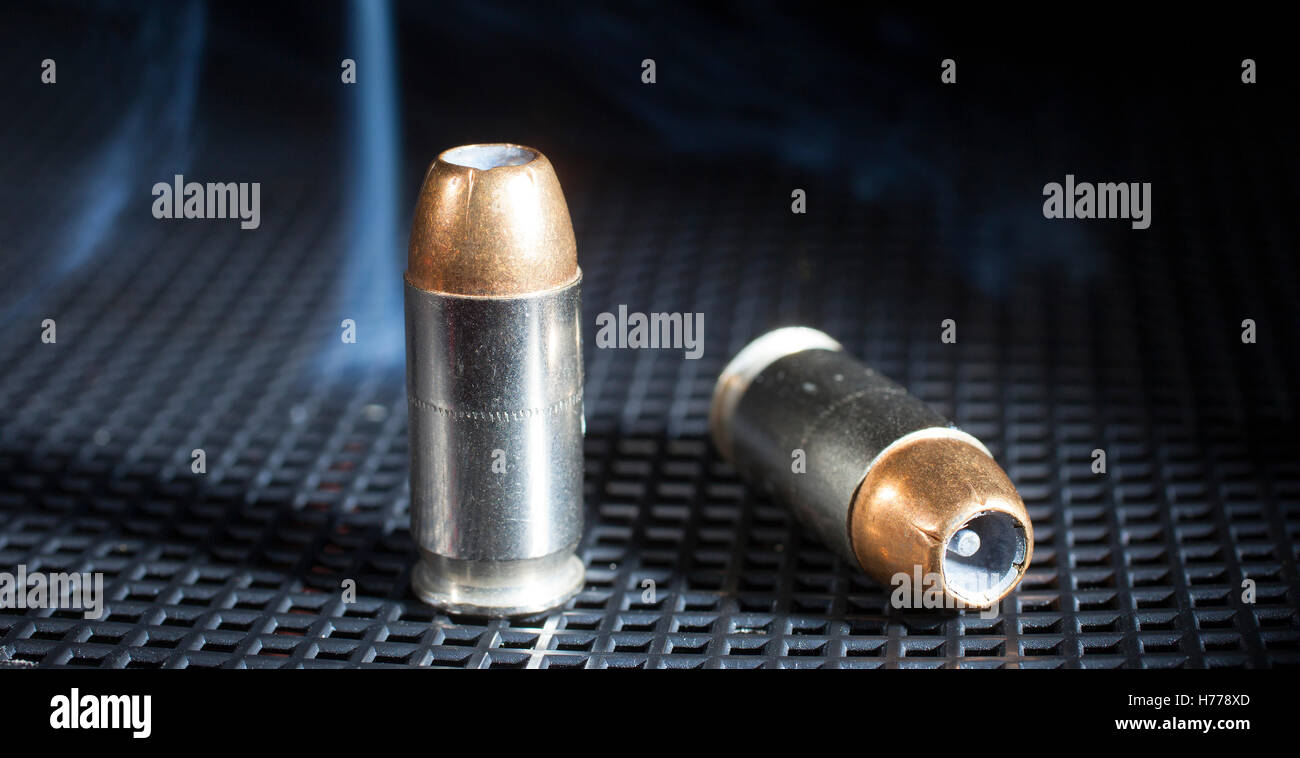 Pair of handgun cartridges on black with smoke behind Stock Photo - Alamy