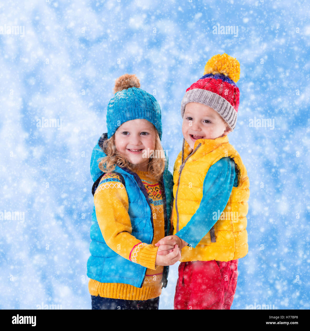 Children play in snowy forest. Toddler kids outdoors in winter. Friends ...