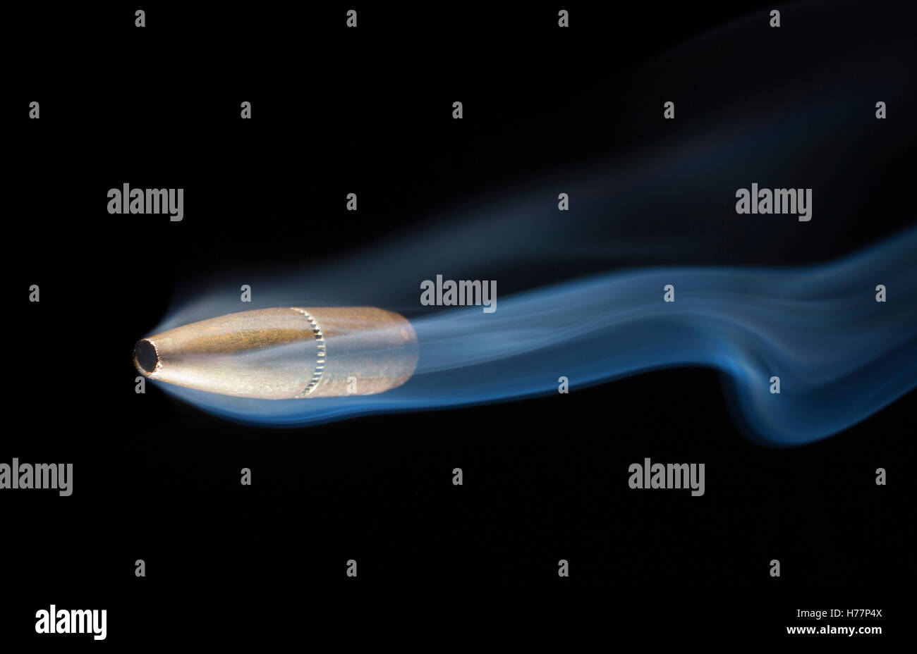 Single copper colored bullet with smoke on a black background Stock ...