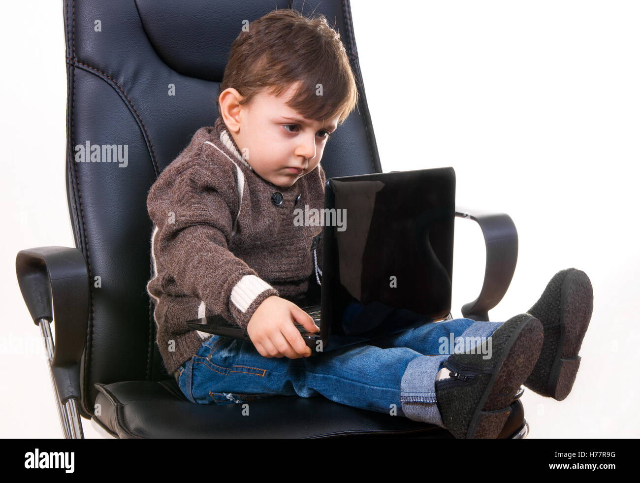 little boy sitting on chair with laptop Stock Photo - Alamy