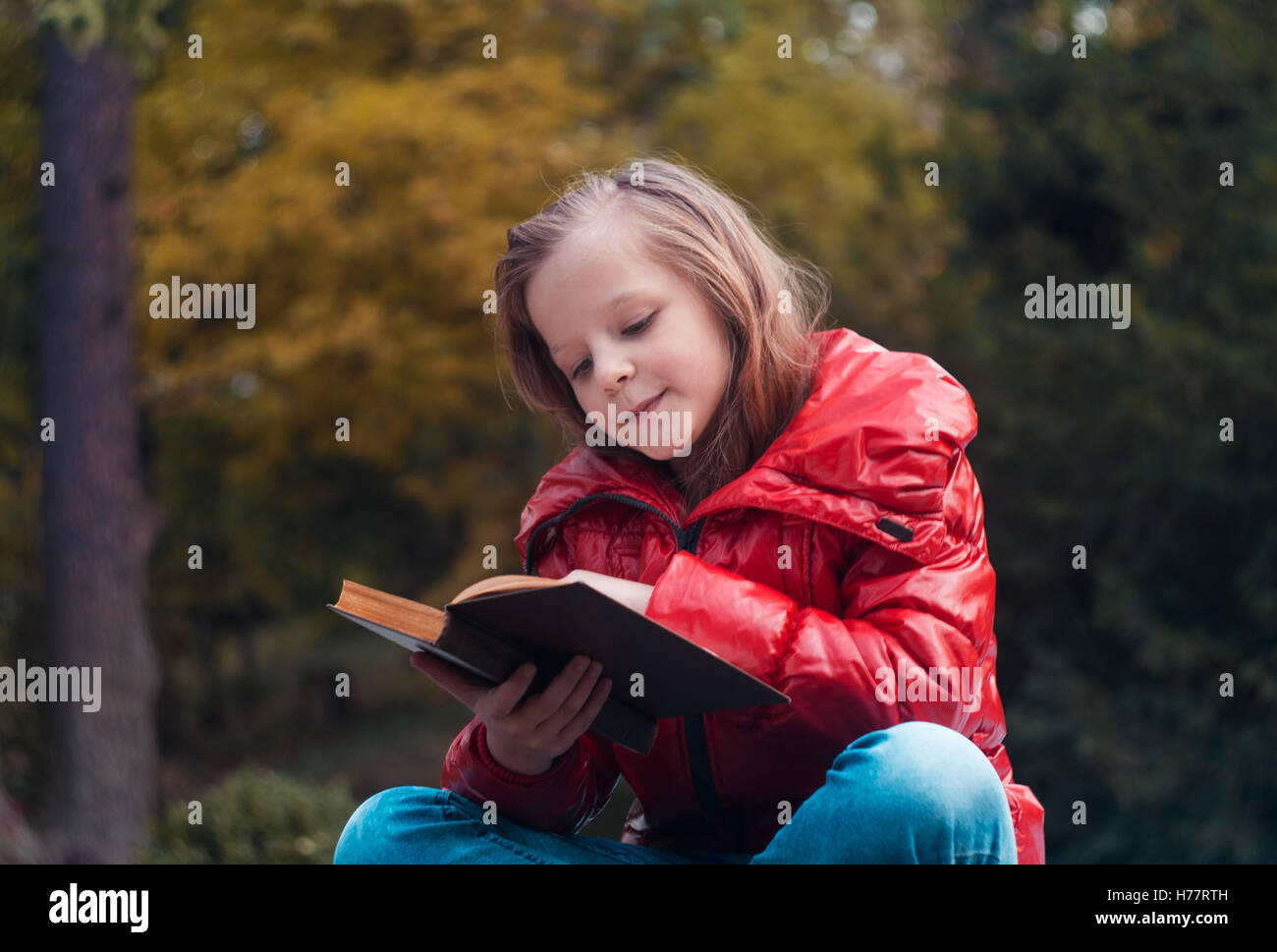 pretty girl portrait in the park reading the book Stock Photo - Alamy