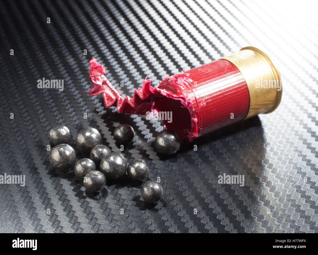 Twelve gauge shotgun that has been opened with buckshot spilling out ...