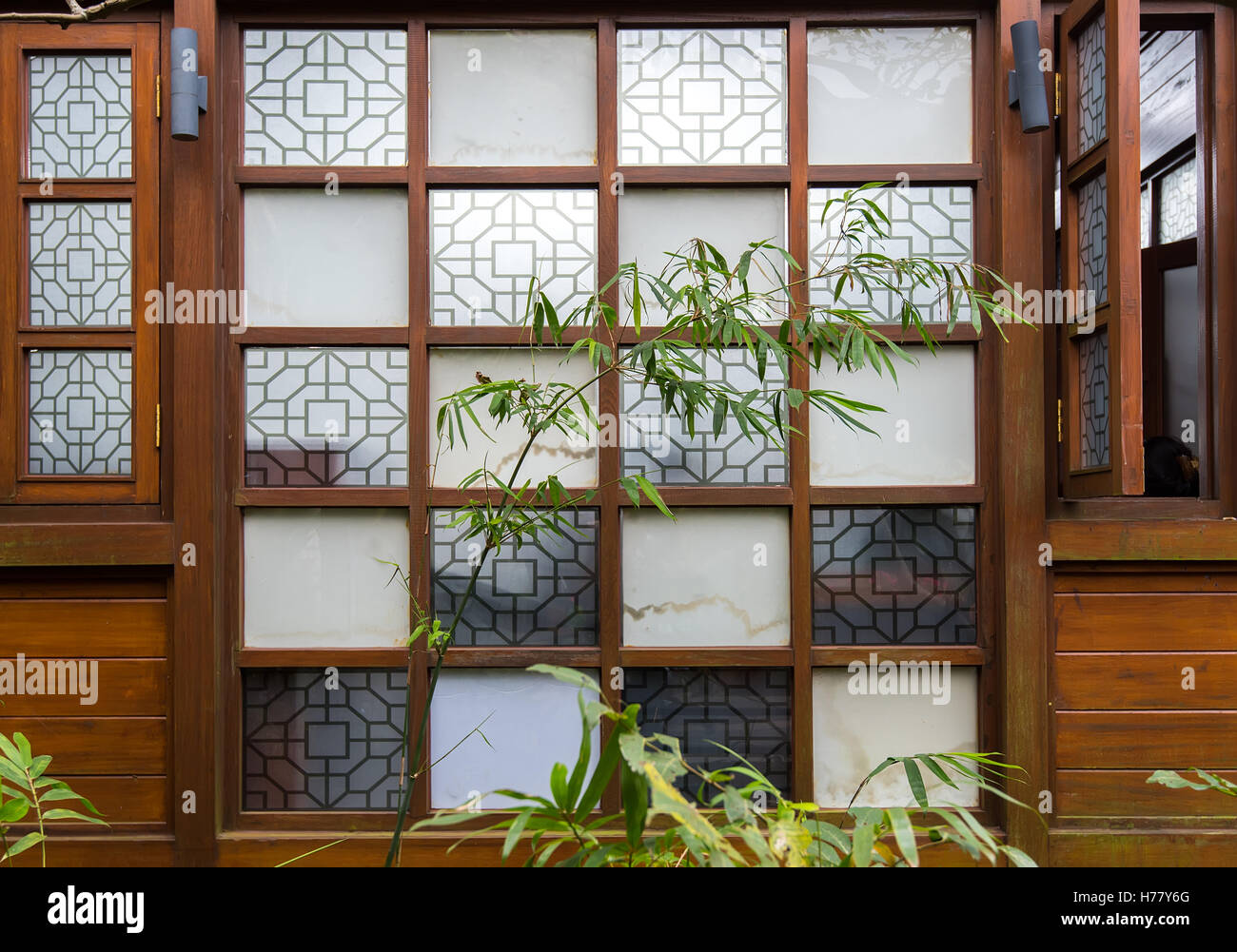 Wall with waving pattern in typical Chinese style with bamboo in front ...