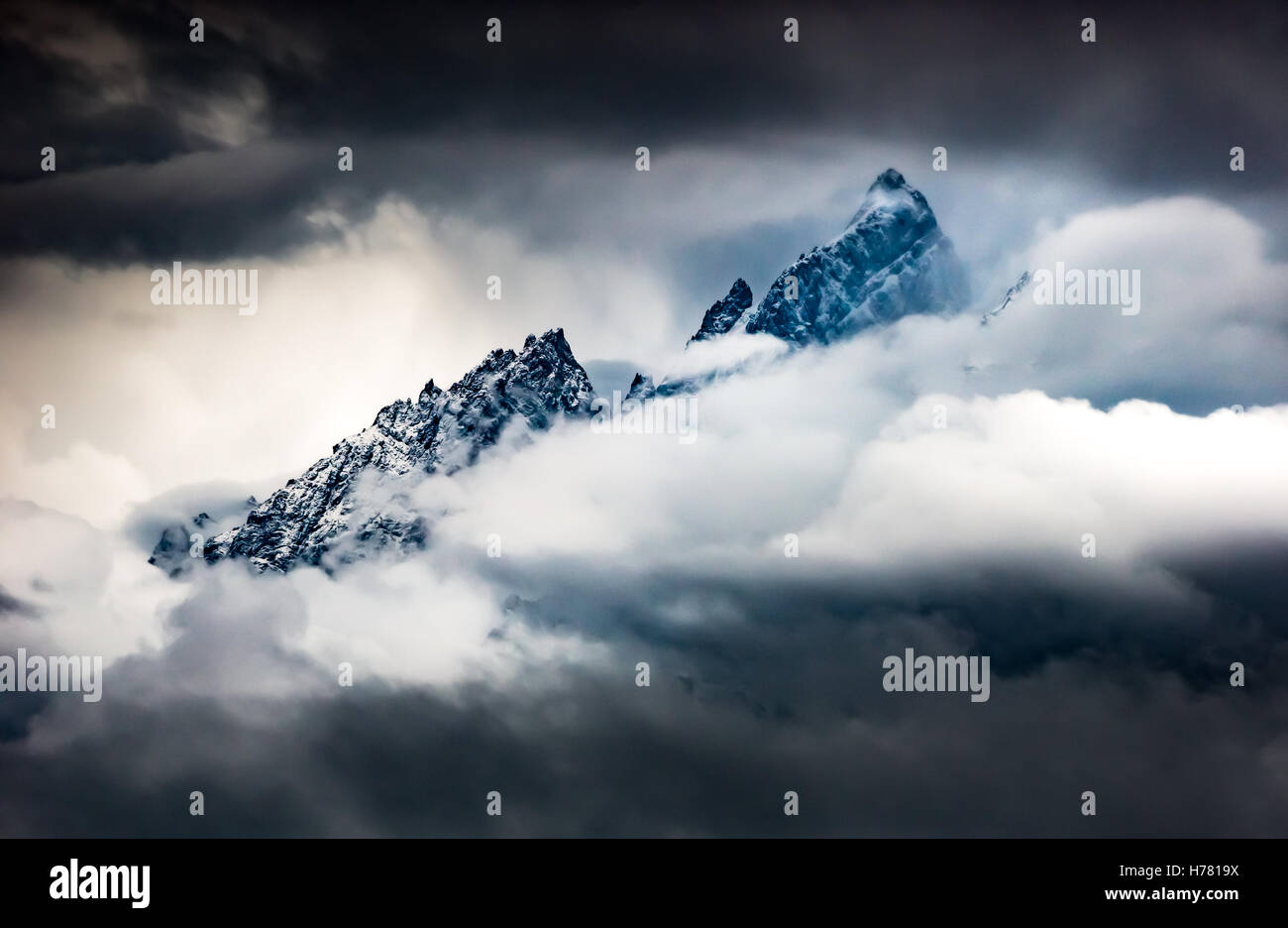 Snow Covered Teton Mountain Crest emerging above thick clouds Stock ...