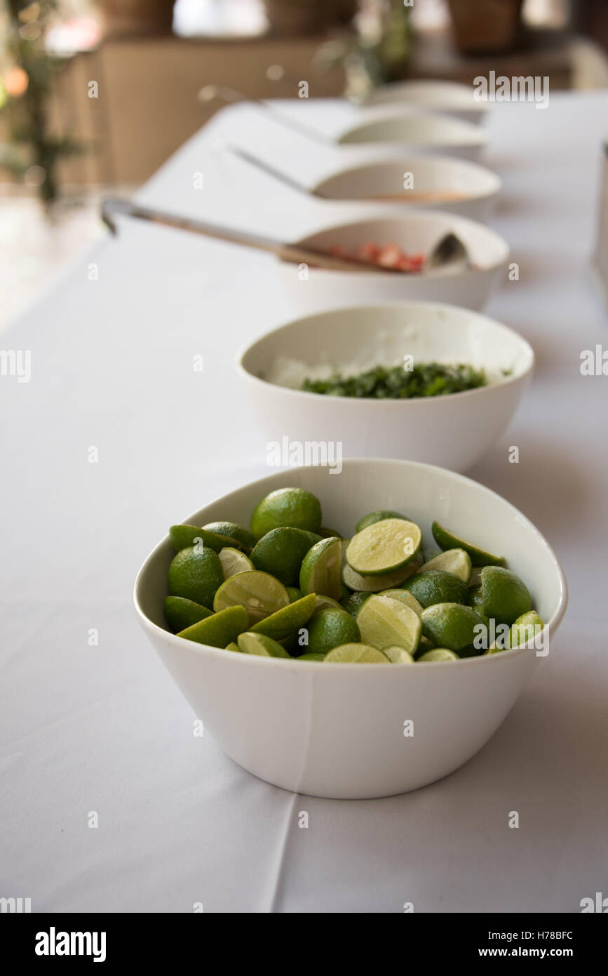 Assorted toppings for Mexican tacos on a buffet table arranged in ...