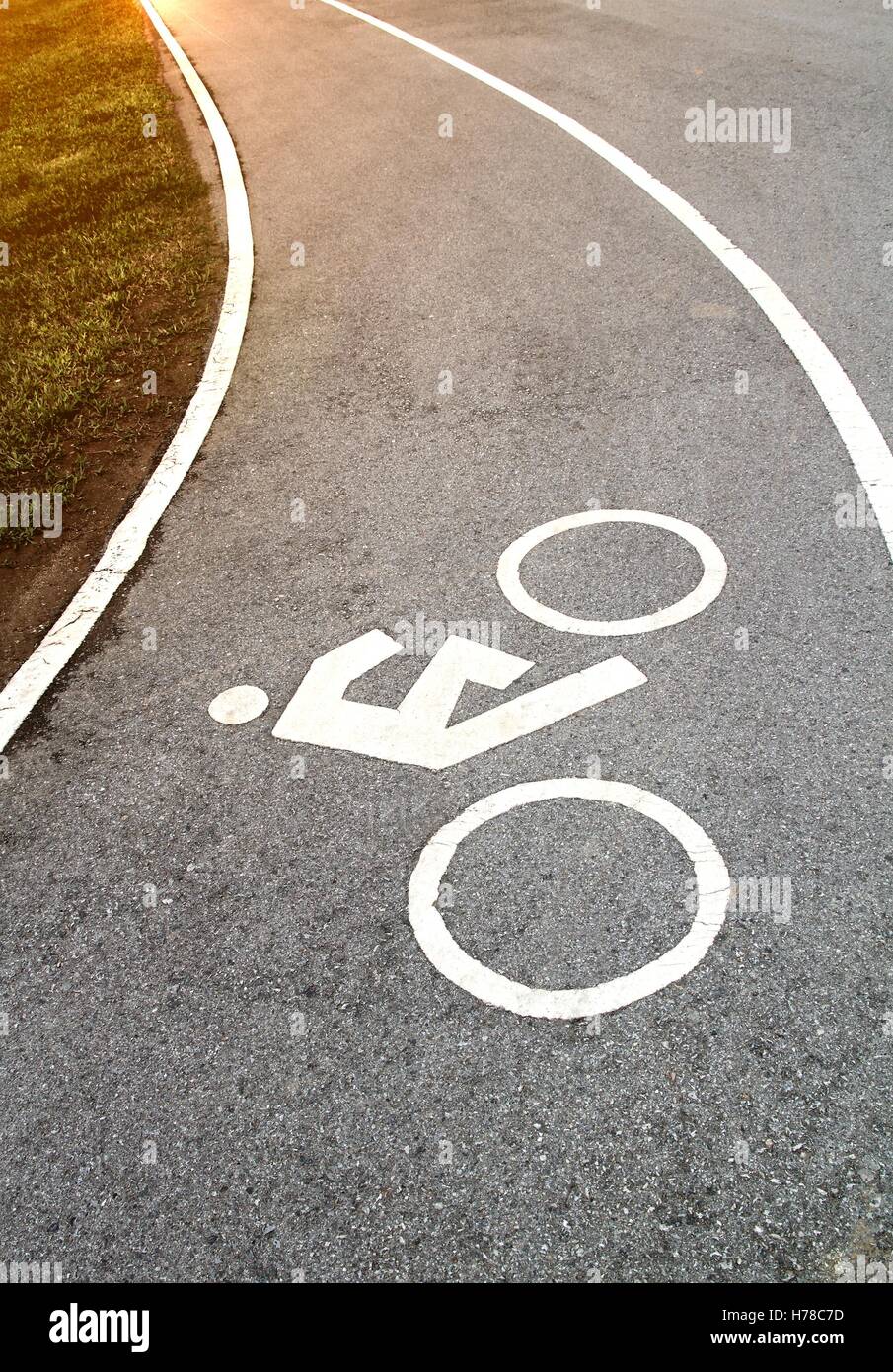 White traffic sign, bicycle lane symbol on curve asphalt road with ...