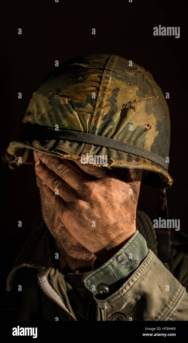 American soldier from the Vietnam War period, with his hands covering ...