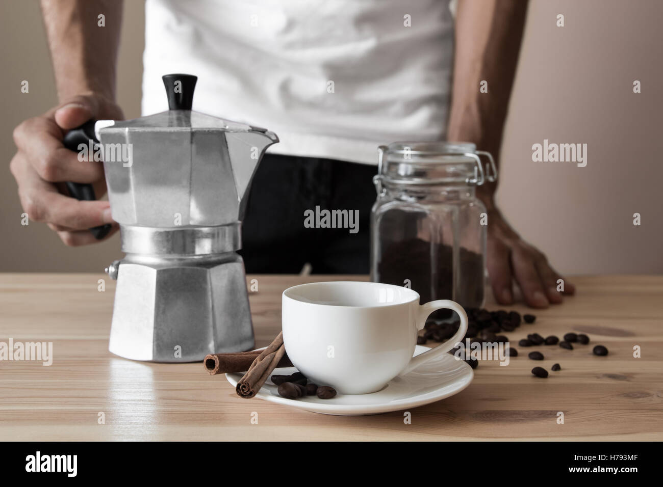 Hands holding coffee pot ready to pour espresso in the white cup Stock ...