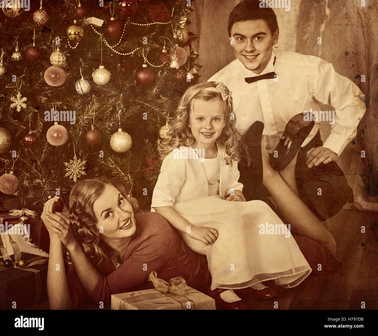 Family with children pose under Christmas tree Stock Photo - Alamy