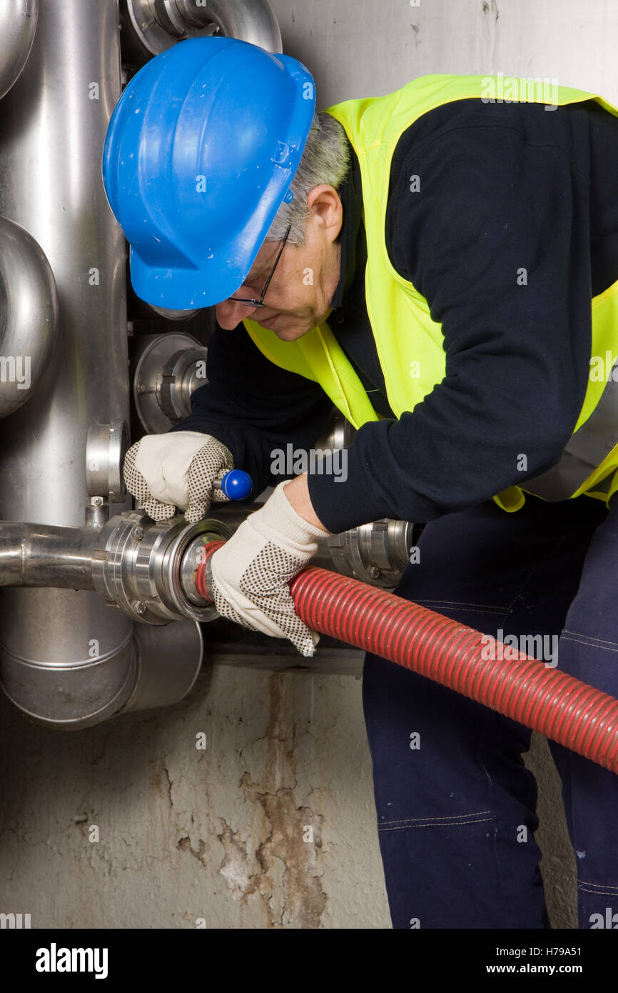 skilled worker fitting a pump in a industrial company Stock Photo - Alamy