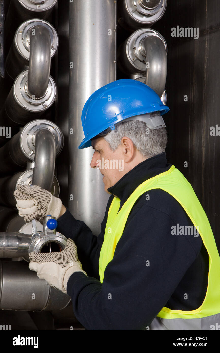 skilled worker fitting a pump in a industrial company Stock Photo - Alamy