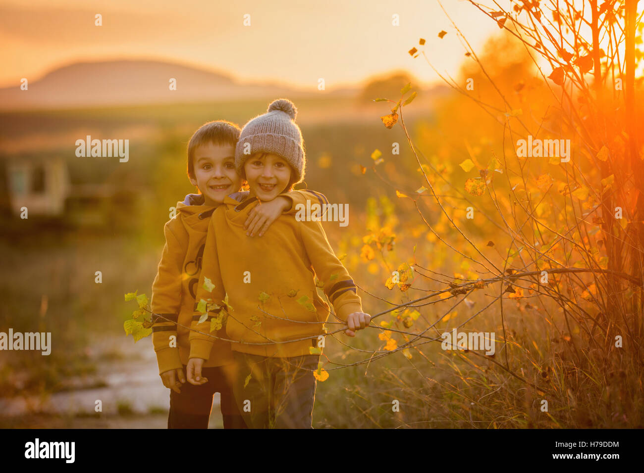 Two adorable children, having fun on sunset, making funny faces and ...
