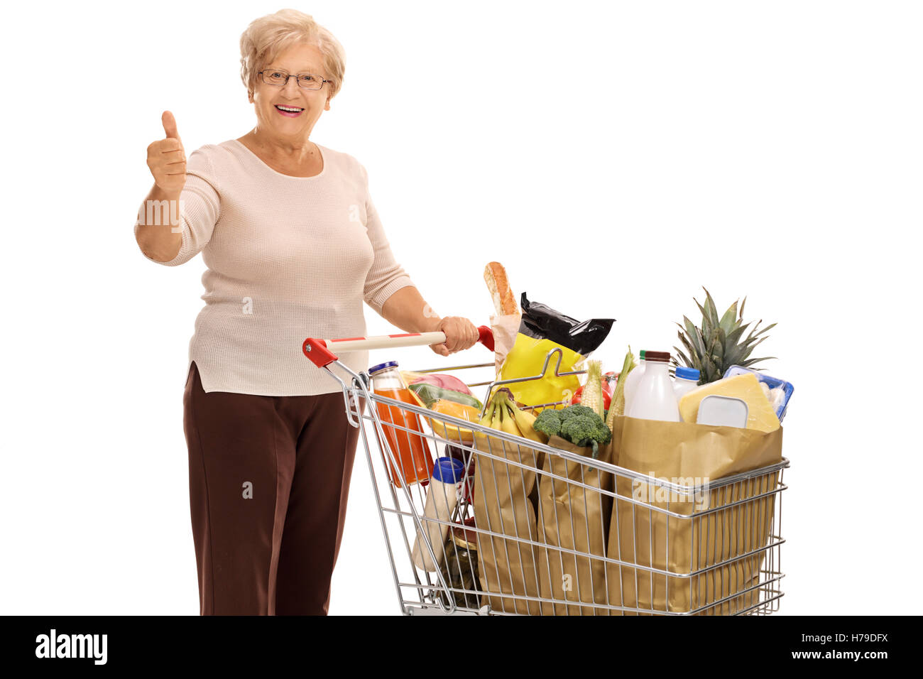 Cheerful mature lady with a shopping cart full of groceries giving a ...