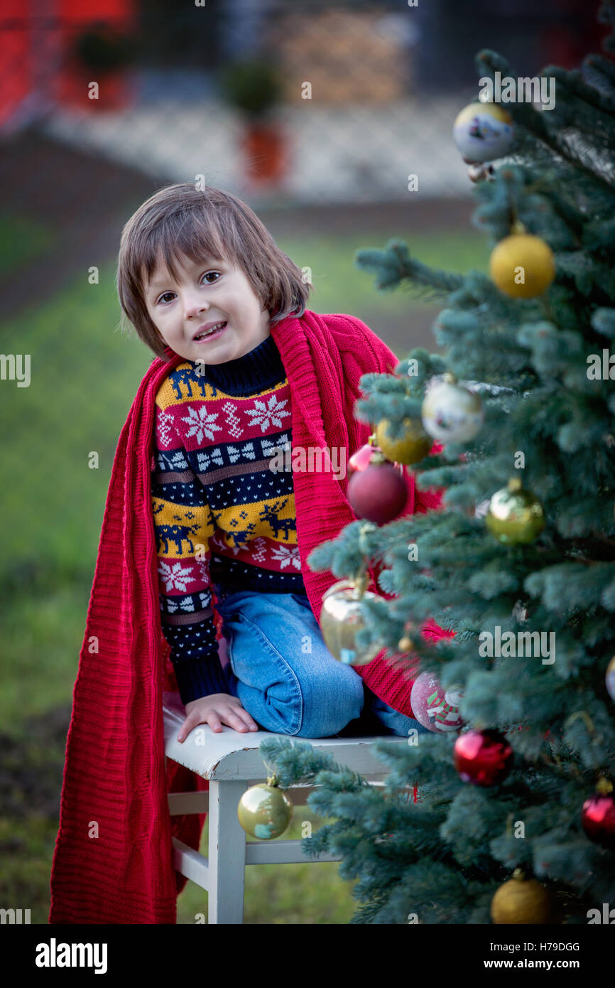 Cute little child, preschool boy, decorating christmas tree, outdoor ...