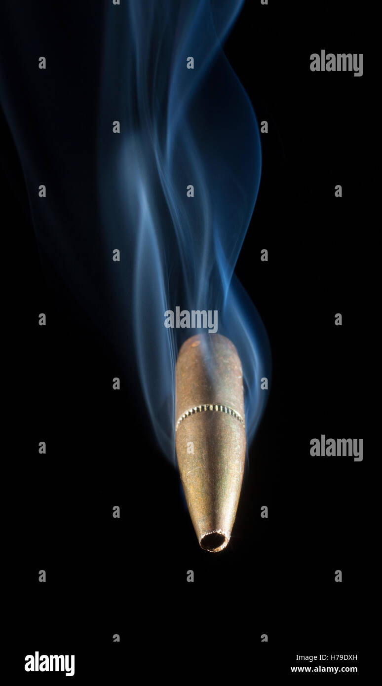 Hollow pointed bullet that is dropping toward the camera with smoke ...