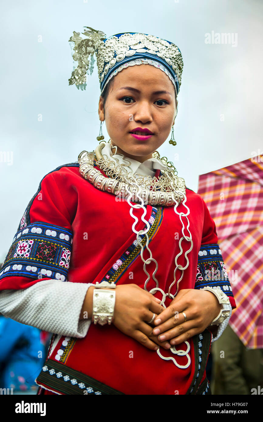 A girl in traditional Miao costume is preparing for the parade of ...