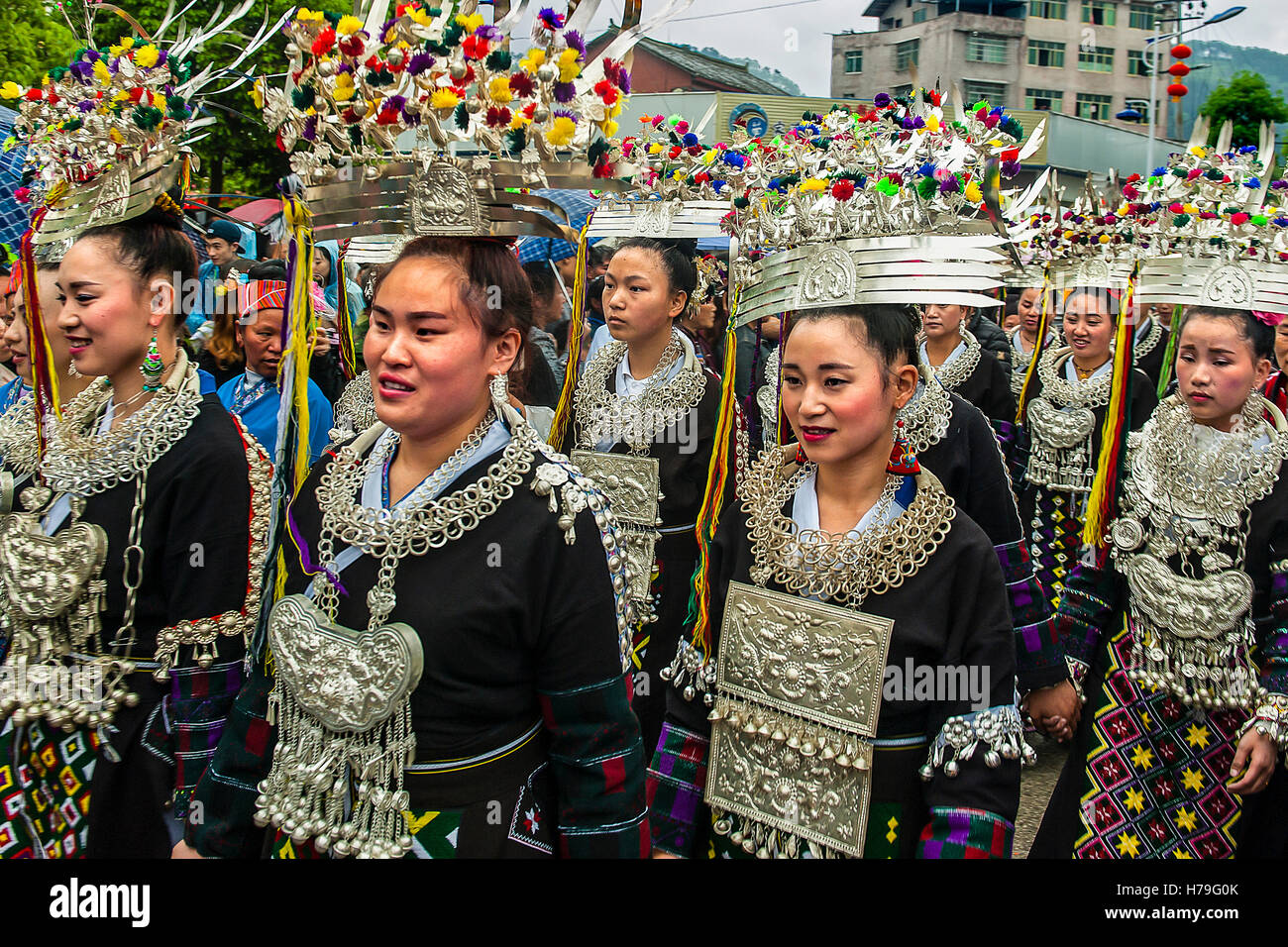 Women in traditional Miao costumes parade along the principal street of ...