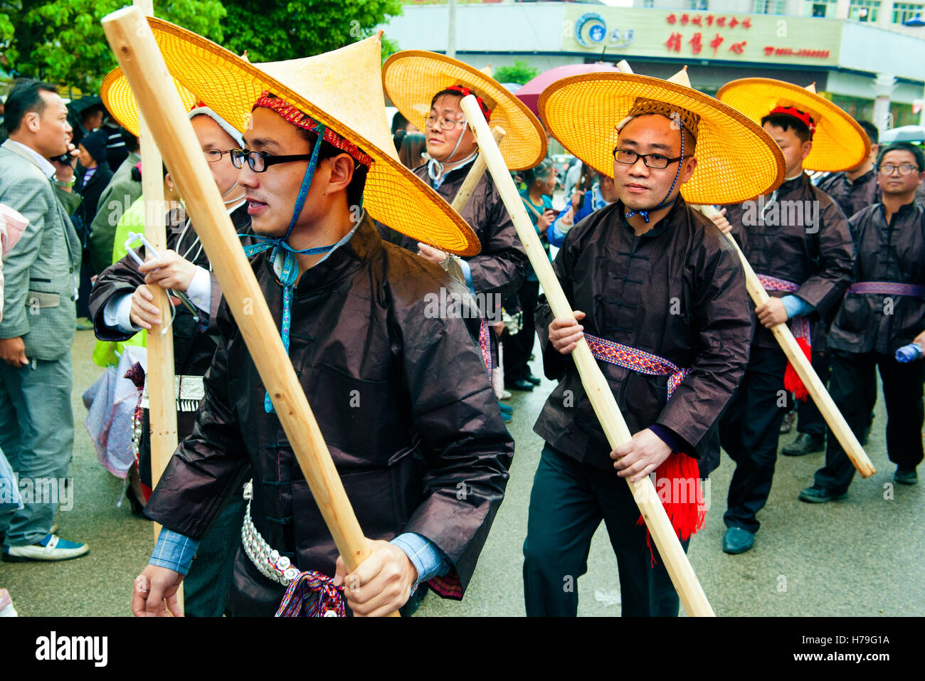 Men in traditional Miao costumes parade along the principal street of ...