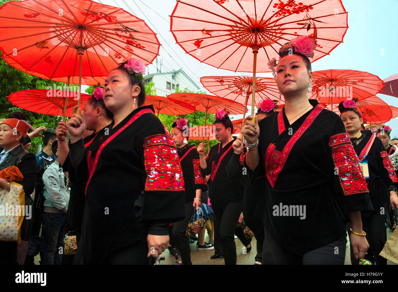 Women in traditional Miao costumes parade along the principal street of ...