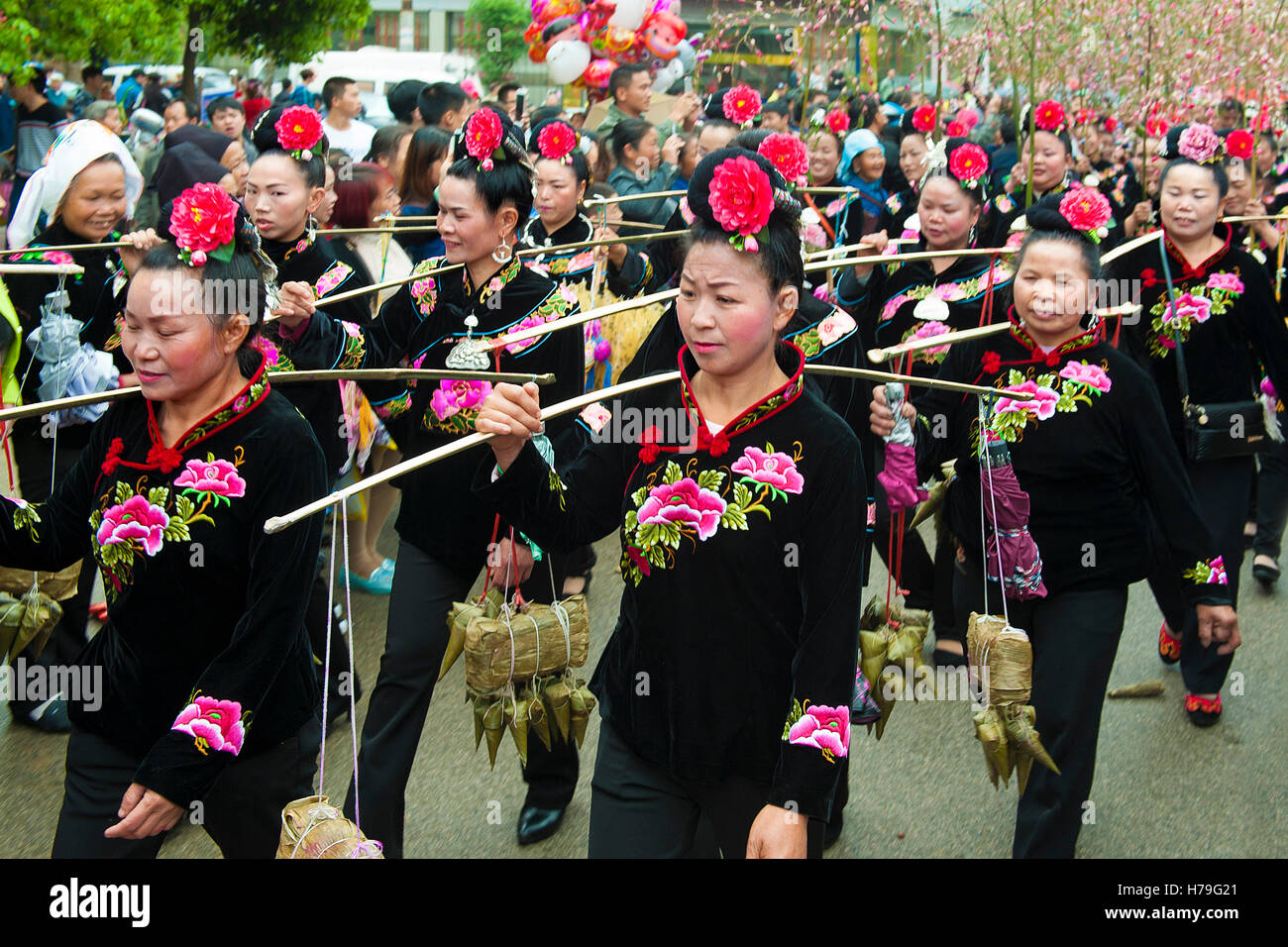 Women in traditional Miao costumes parade along the principal street of ...