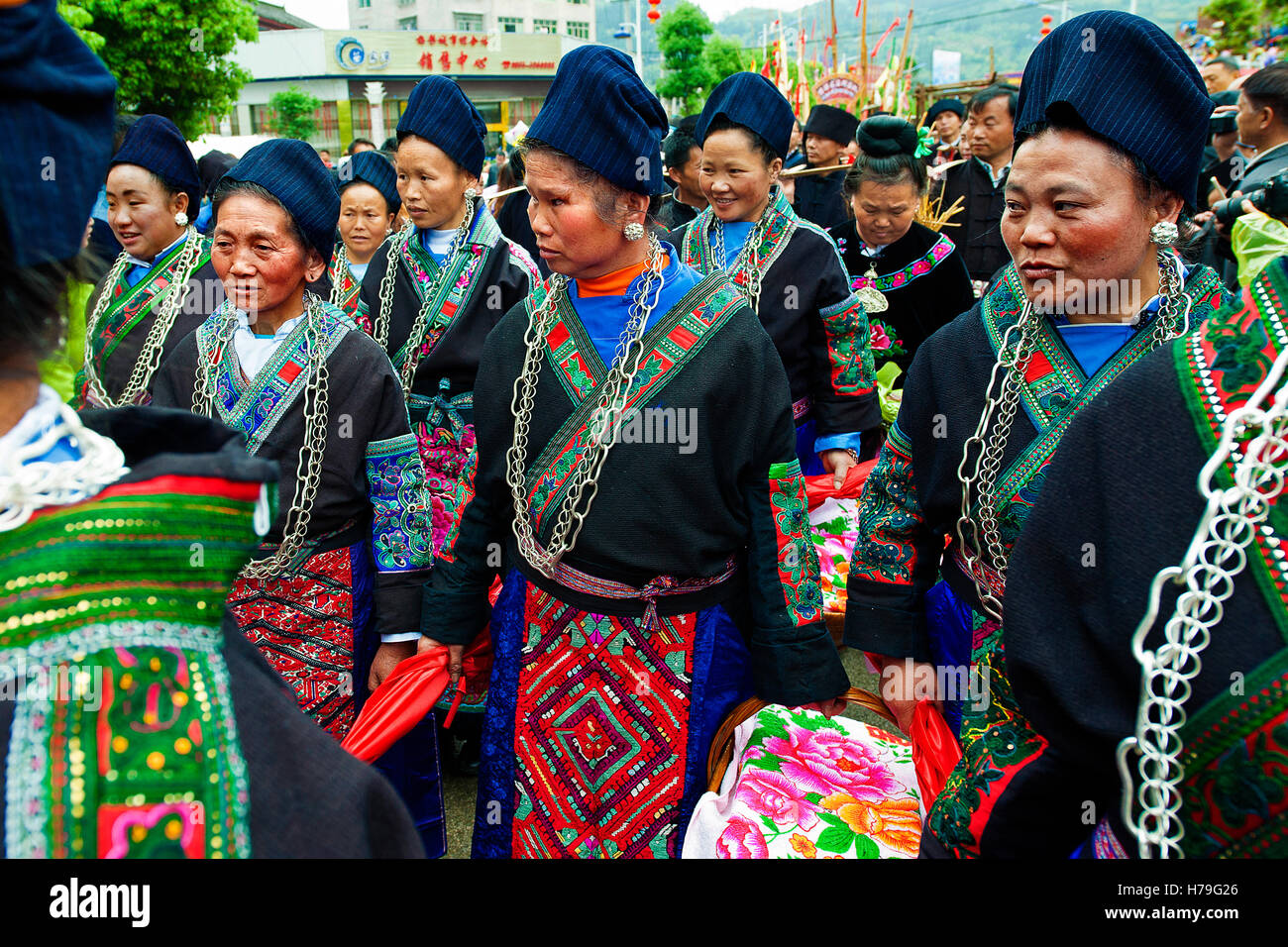 Women in traditional Miao costumes parade along the principal street of ...