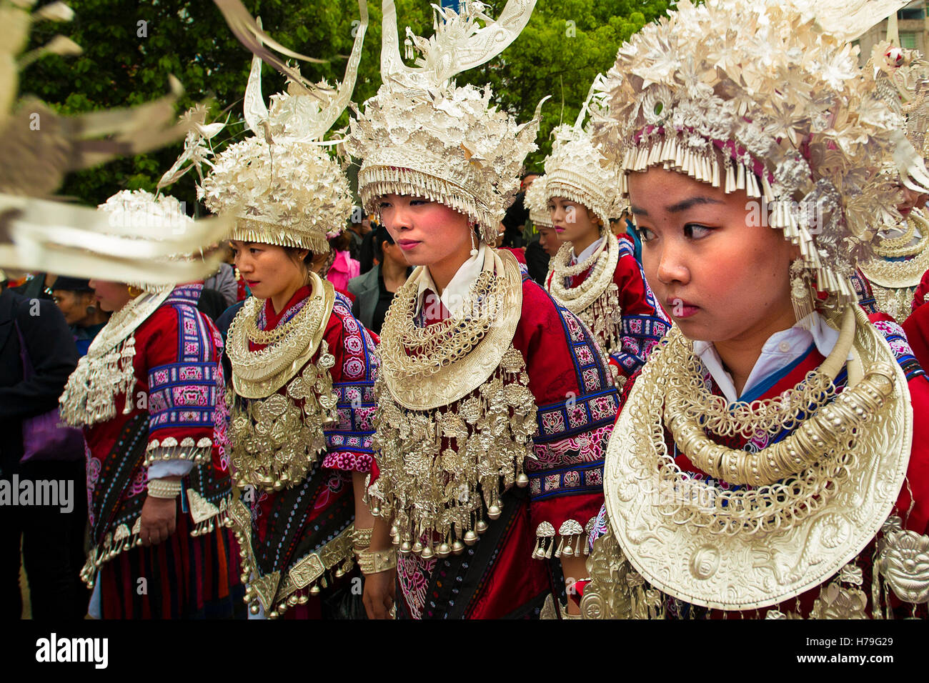 Girls in traditional Miao costumes parade along the principal street of ...