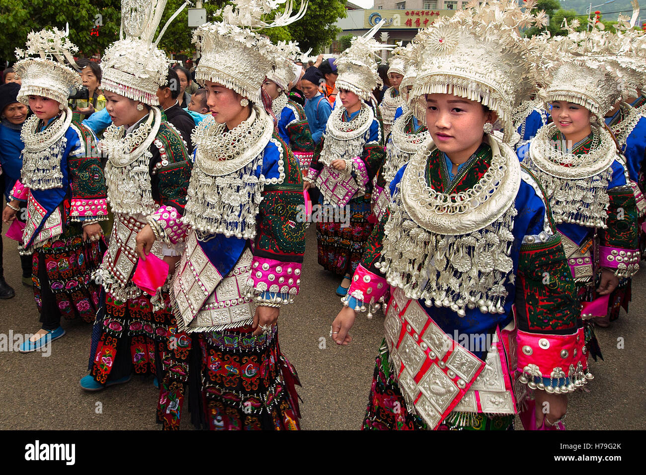 Girl in traditional Miao costumes parades along the principal street of ...