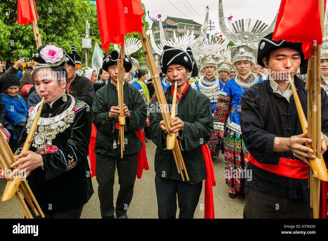 Women and men in traditional Miao costumes playing instruments during ...