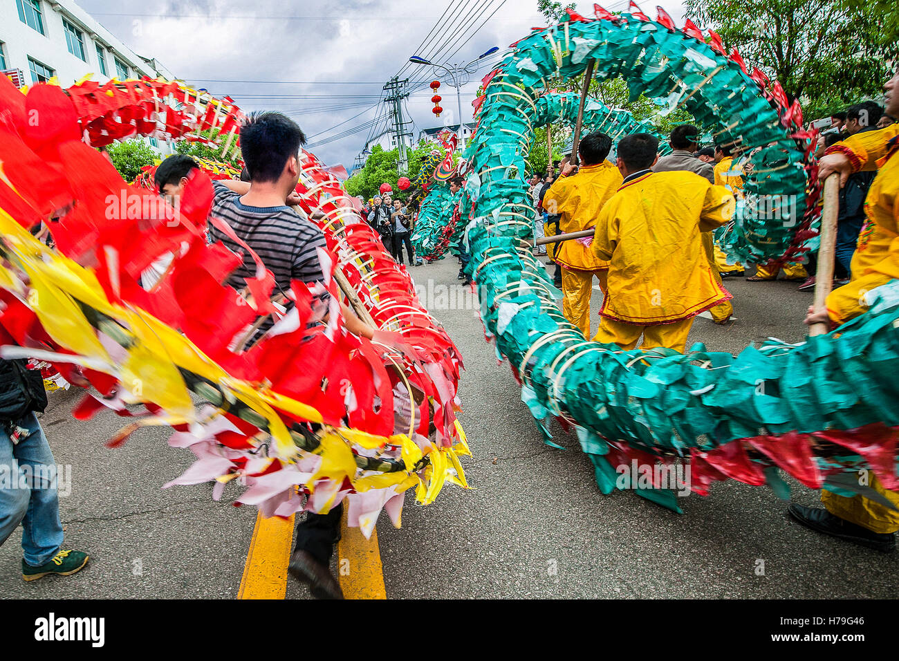 Men drive rotating dragons of paper at the end of the parade of the ...