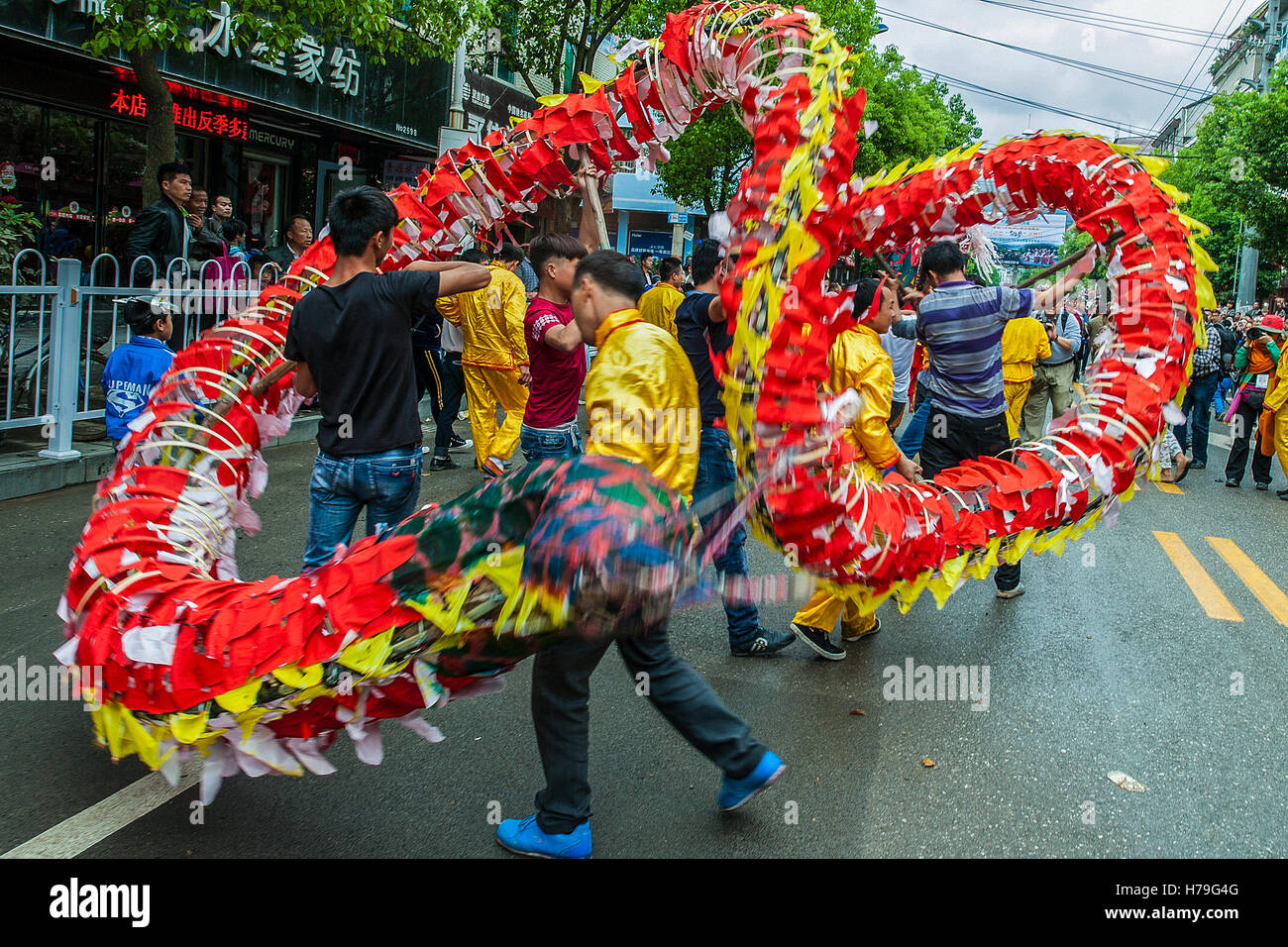 Men drive rotating dragons of paper at the end of the parade of the ...
