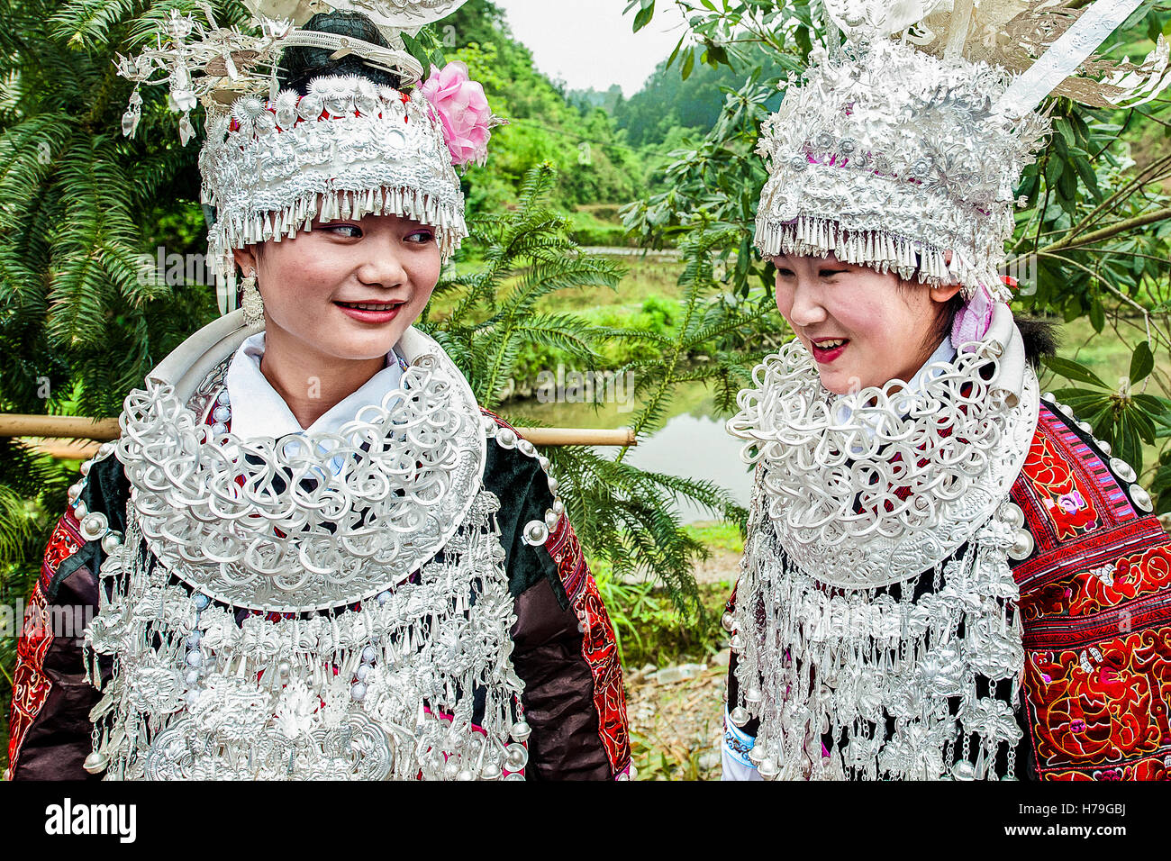 Miao girls in traditional costumes in the lush valley surrounding ...